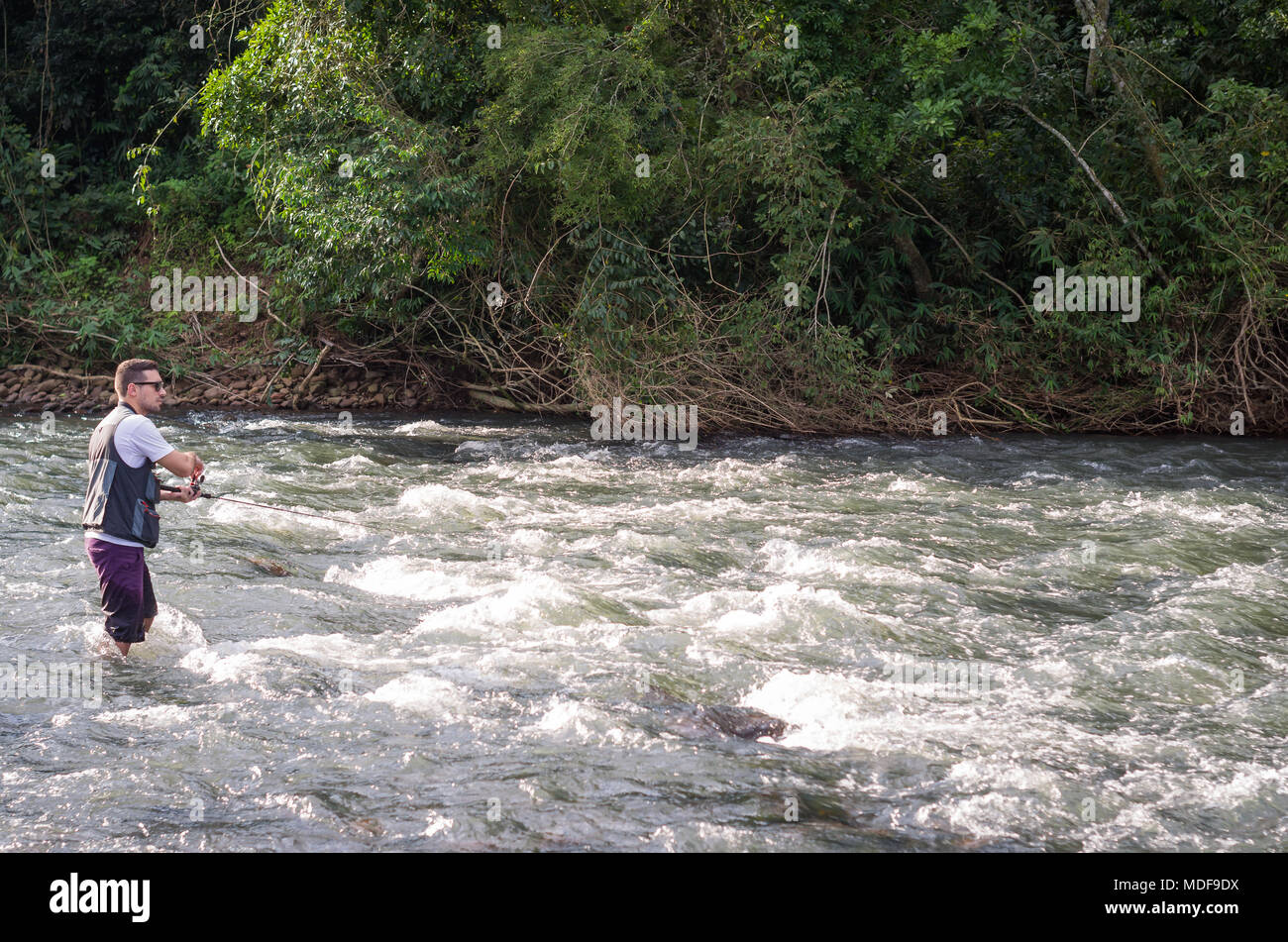 Young man practicing sport fishing in Rio de Janeiro, fishing Jacundá ...