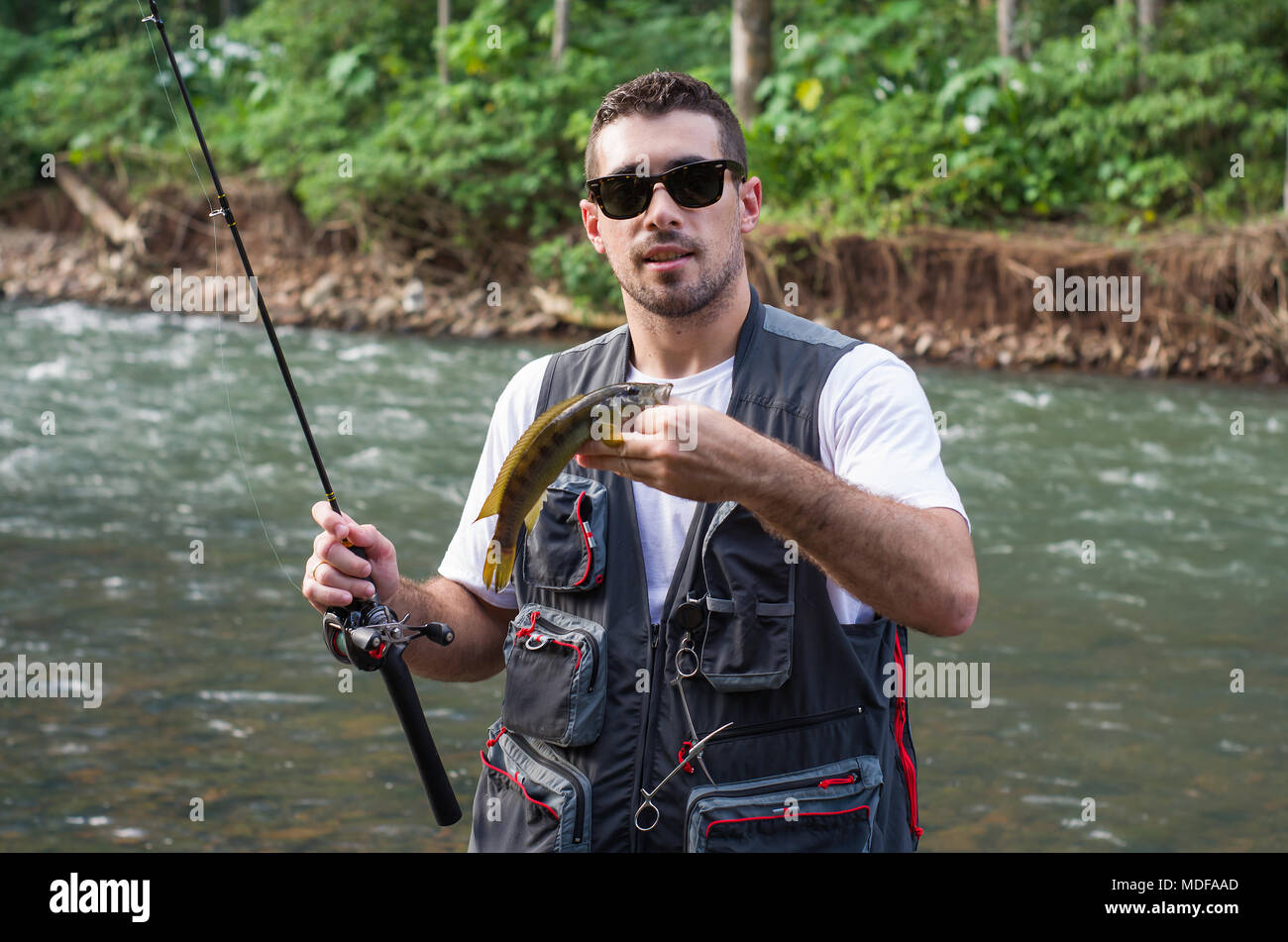 Young man practicing sport fishing in Rio de Janeiro, fishing Jacundá ...