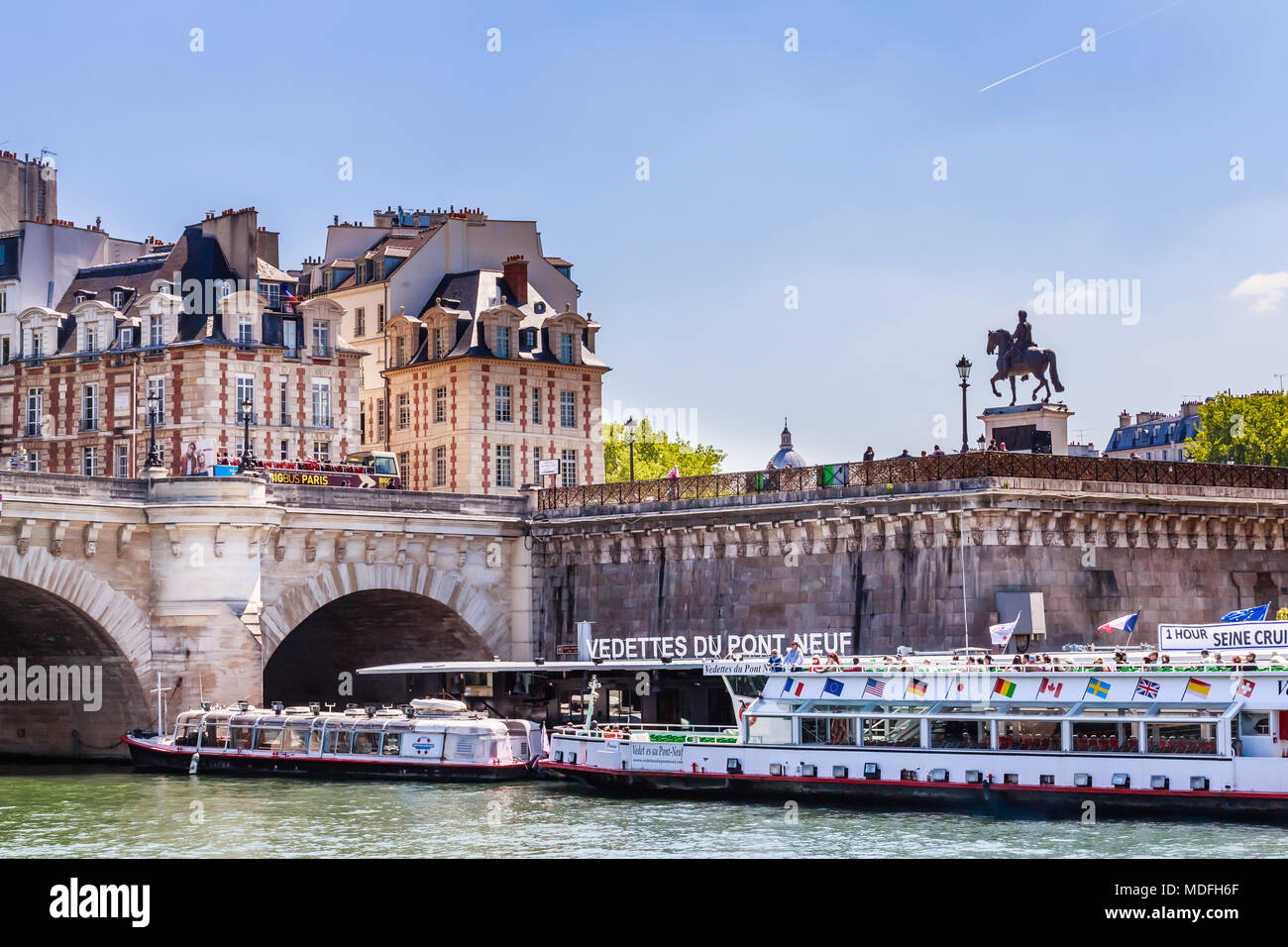 The Vedettes du Pont Neuf tour boat on the Seine River near a bridge ...