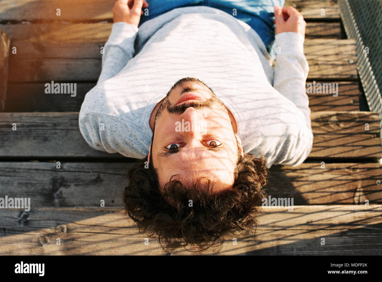 Overhead view of a man sitting on wooden steps Stock Photo - Alamy