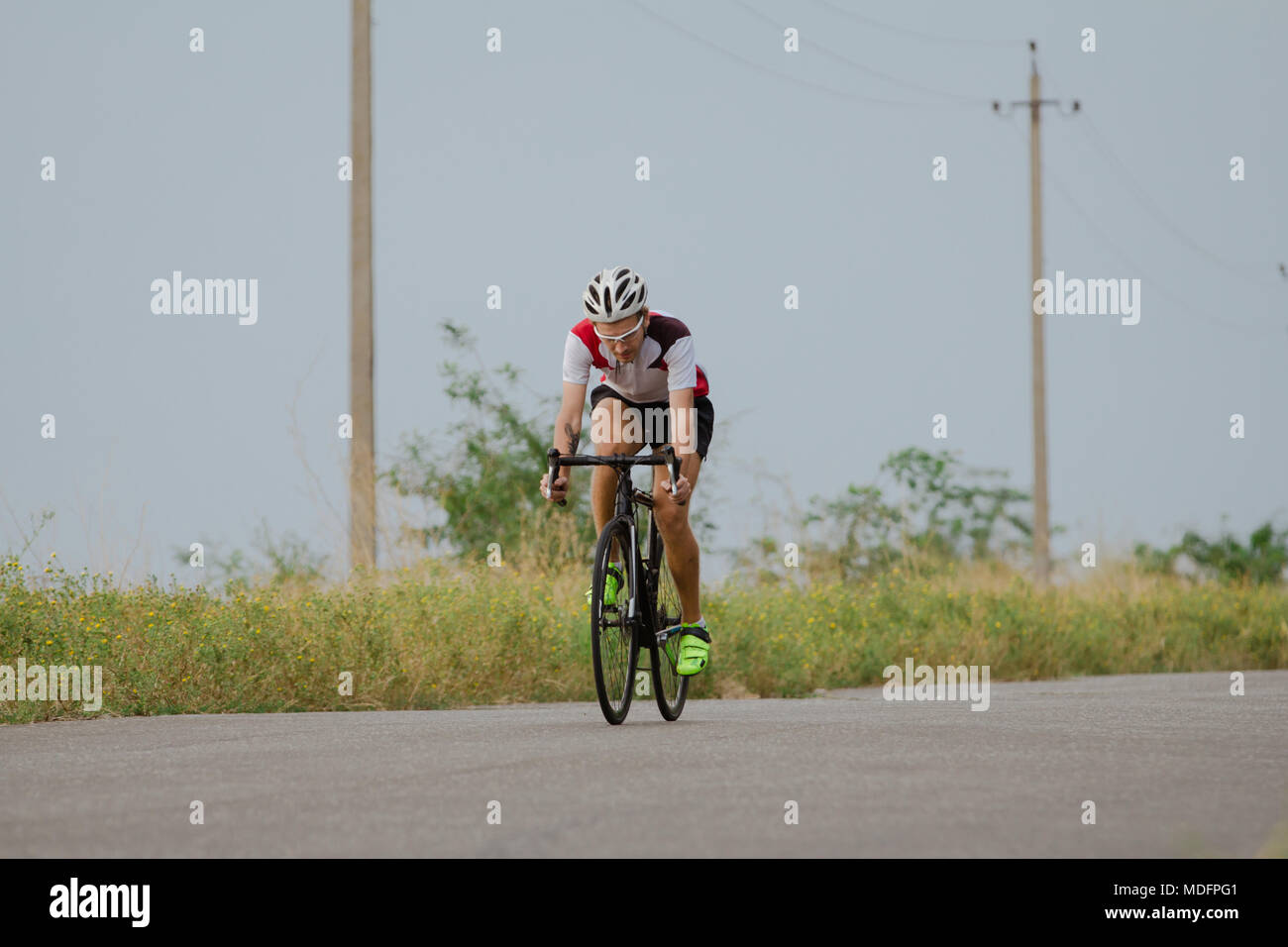 Young male bicycle rider training outdoors on country road, bike racer ...
