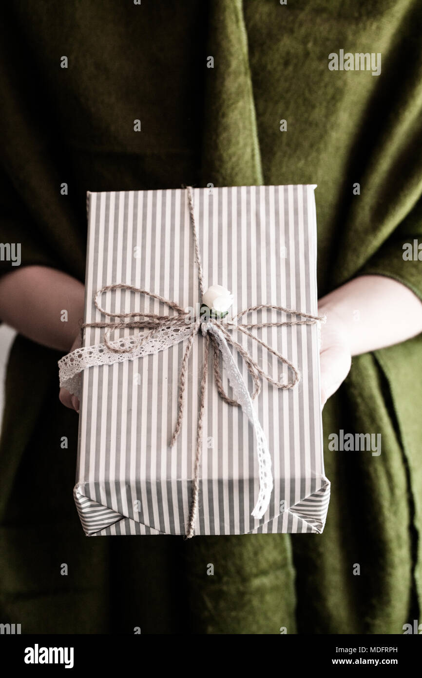 Girl's hand holding a wrapped gift Stock Photo - Alamy