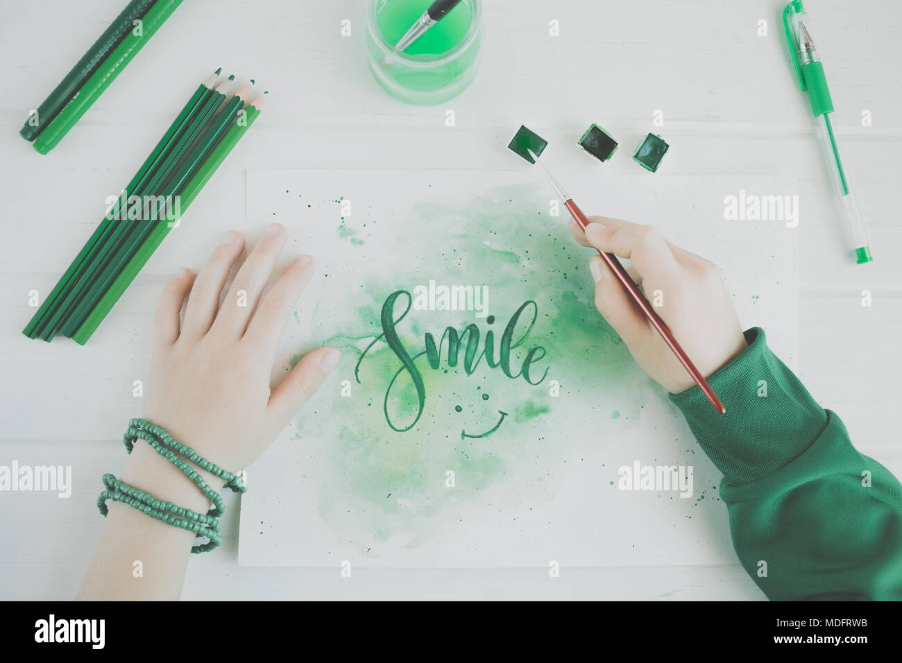 Boy writing the word smile with watercolour paint Stock Photo - Alamy