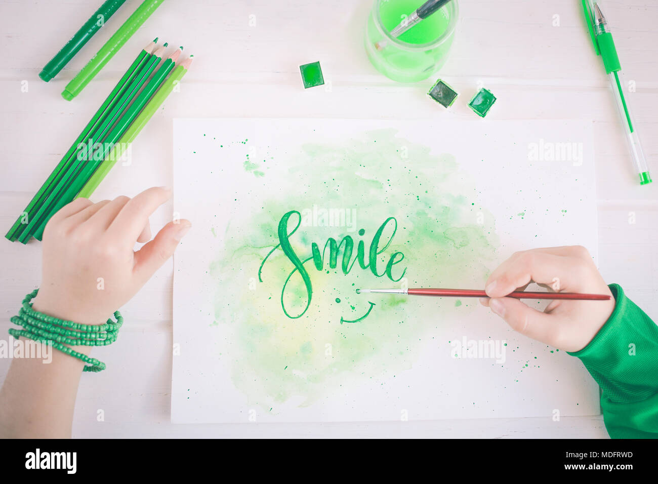 Boy writing the word smile with watercolour paint Stock Photo - Alamy