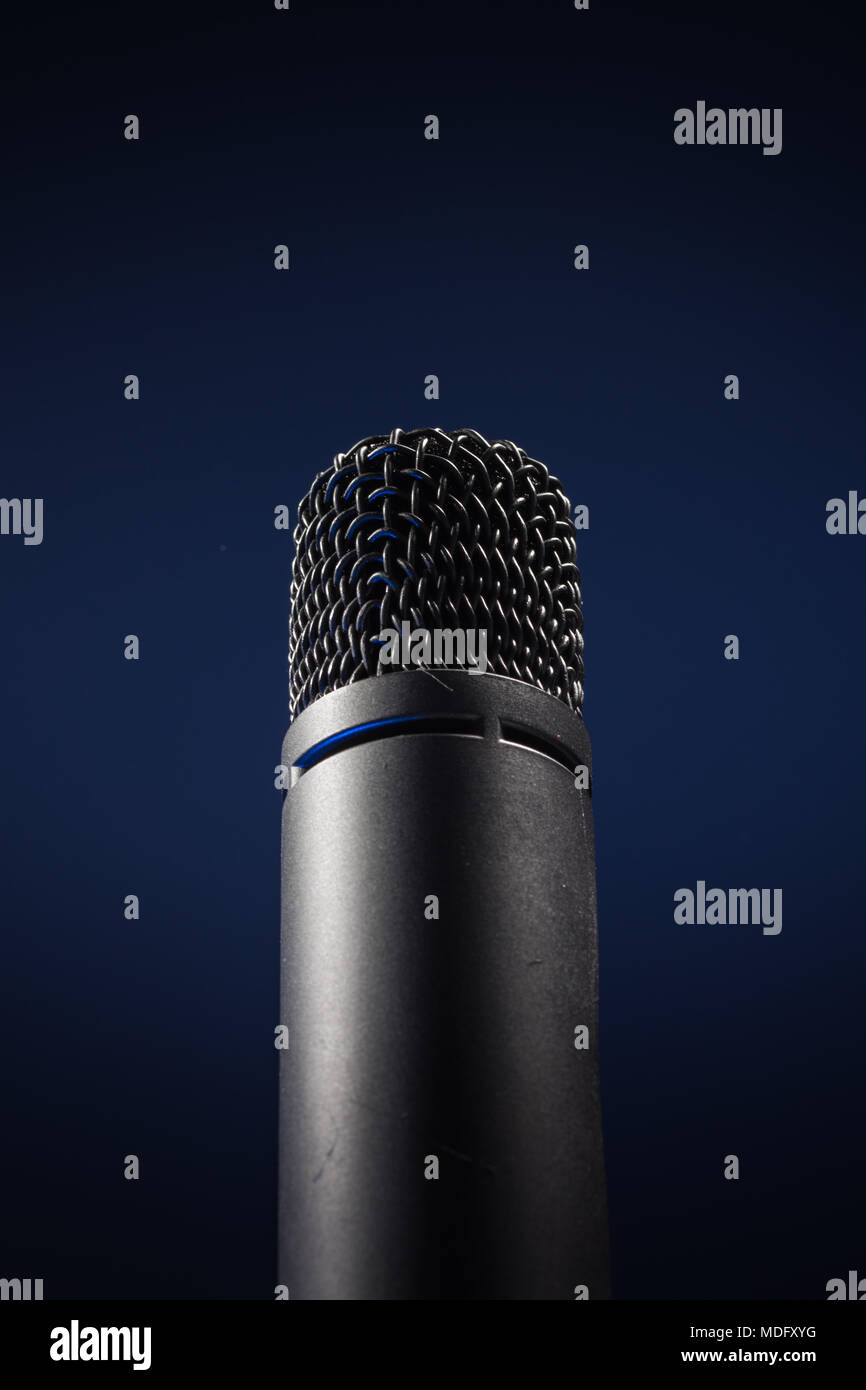 Black microphone blue stage background Stock Photo - Alamy