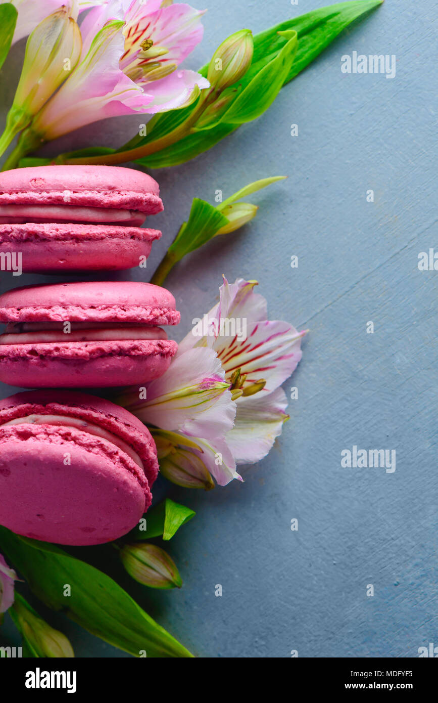 Pink macaroon close-up with spring flowers and buds. French dessert on ...