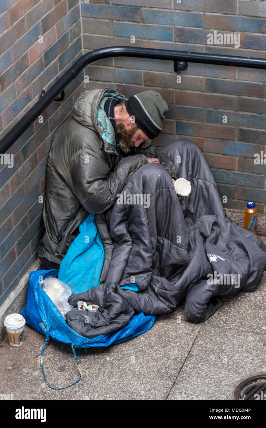 A homeless man sitting in a stairwell on some steps on tower bridge in ...