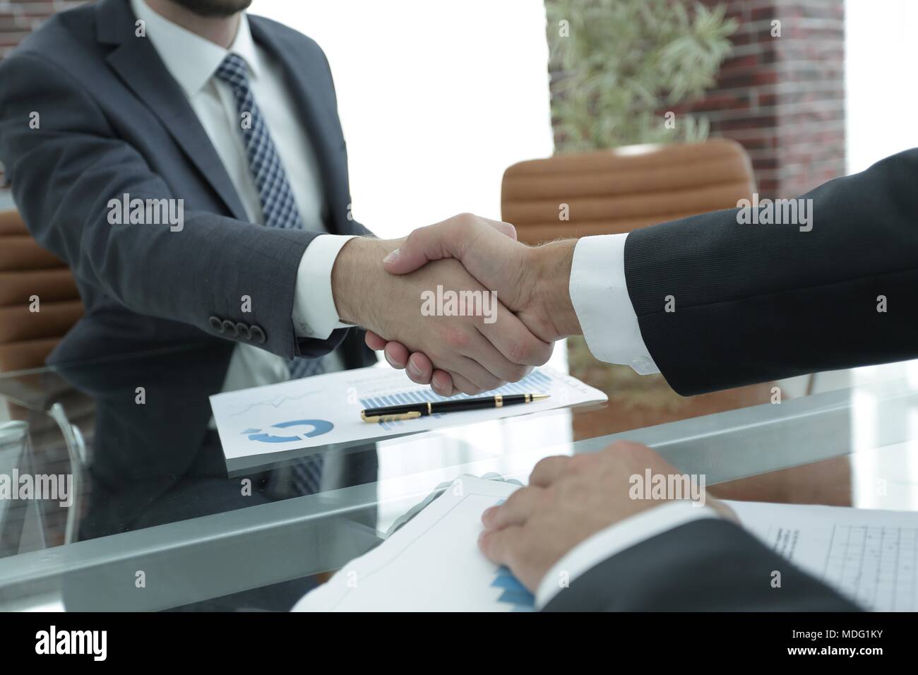 financial partners handshake after signing contract Stock Photo - Alamy