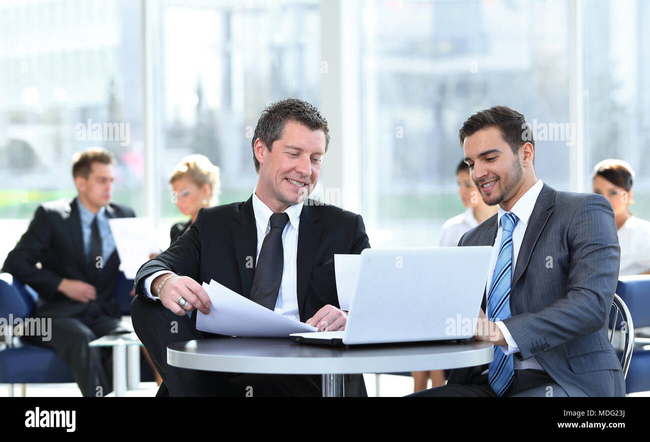 business partners discussing a new project, sitting in the lobby of the ...