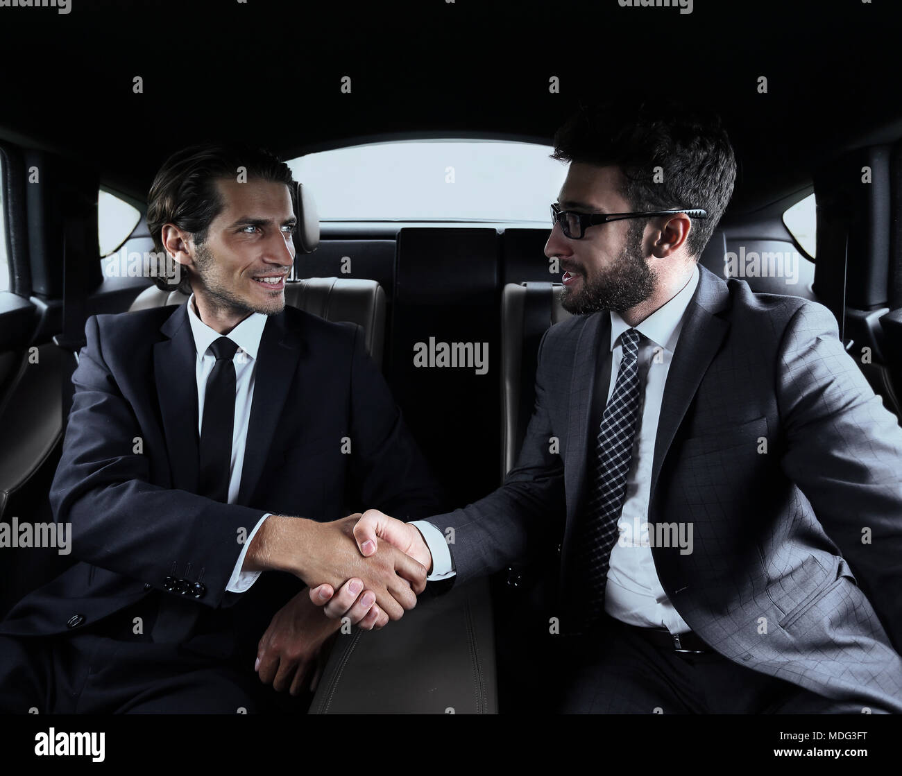 handshake of business partners sitting in the car Stock Photo - Alamy