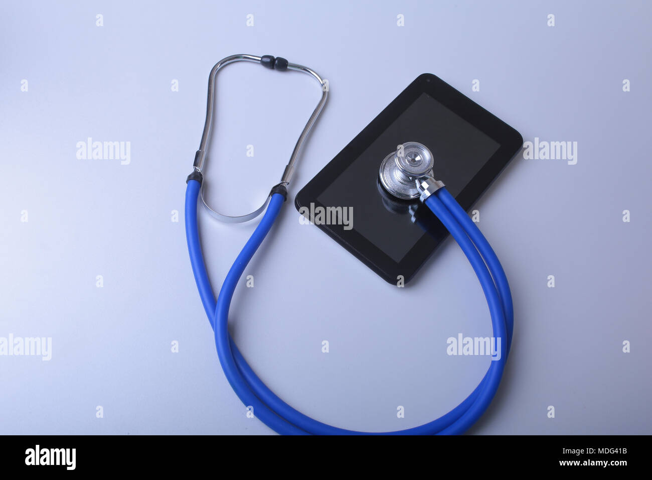 Medical equipment: blue stethoscope and tablet on white background ...