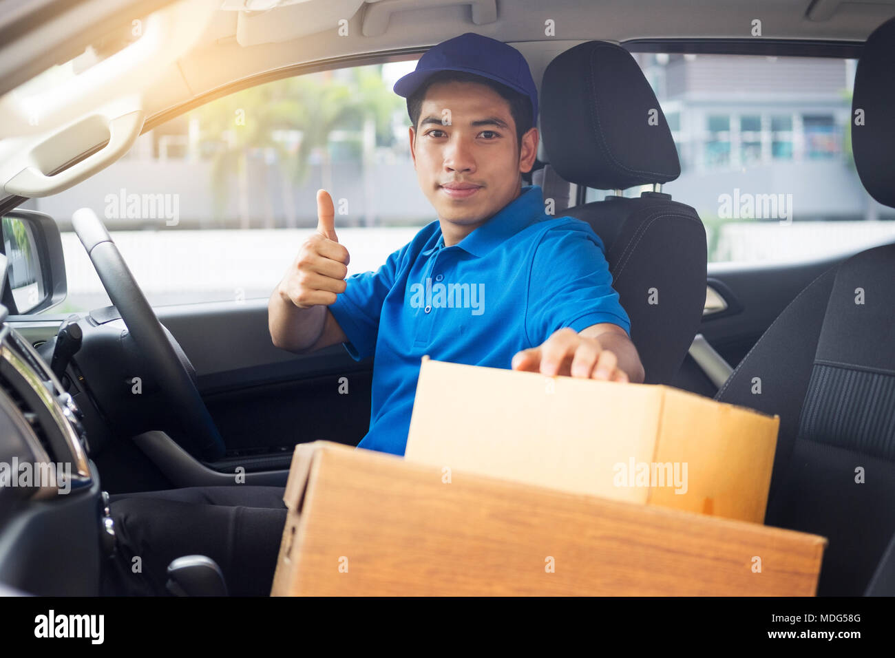 Delivery messenger man with cardboard box outside the warehouse Stock ...