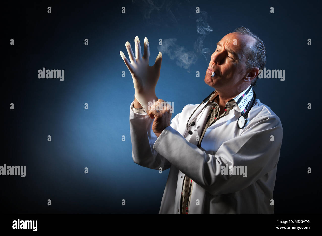 Medical doctor smoking while pulling on gloves Stock Photo - Alamy