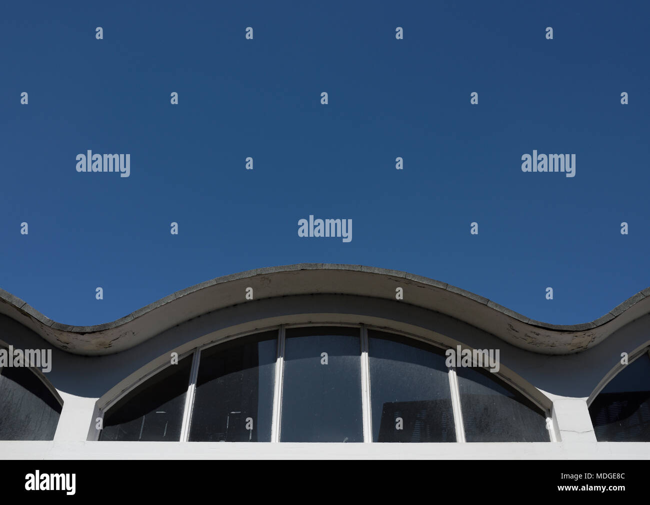 Curvilinear roof detail and glass window panes on disused fire station ...