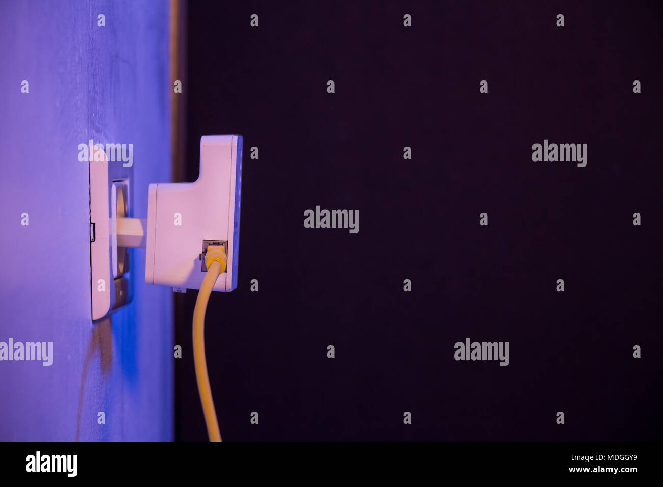 WiFi extender in electrical socket on the wall with ethernet cable ...