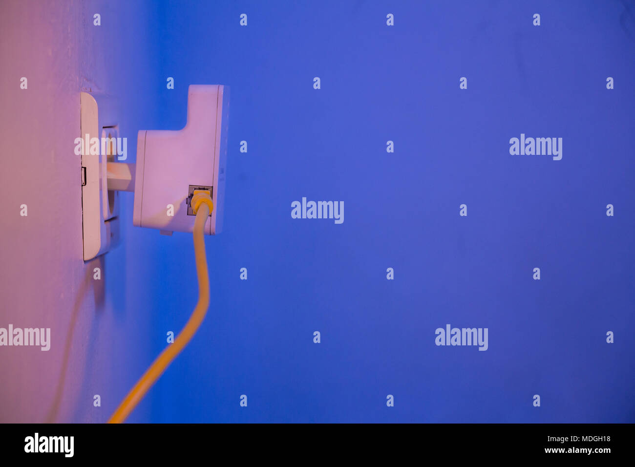WiFi extender in electrical socket on the wall with ethernet cable ...