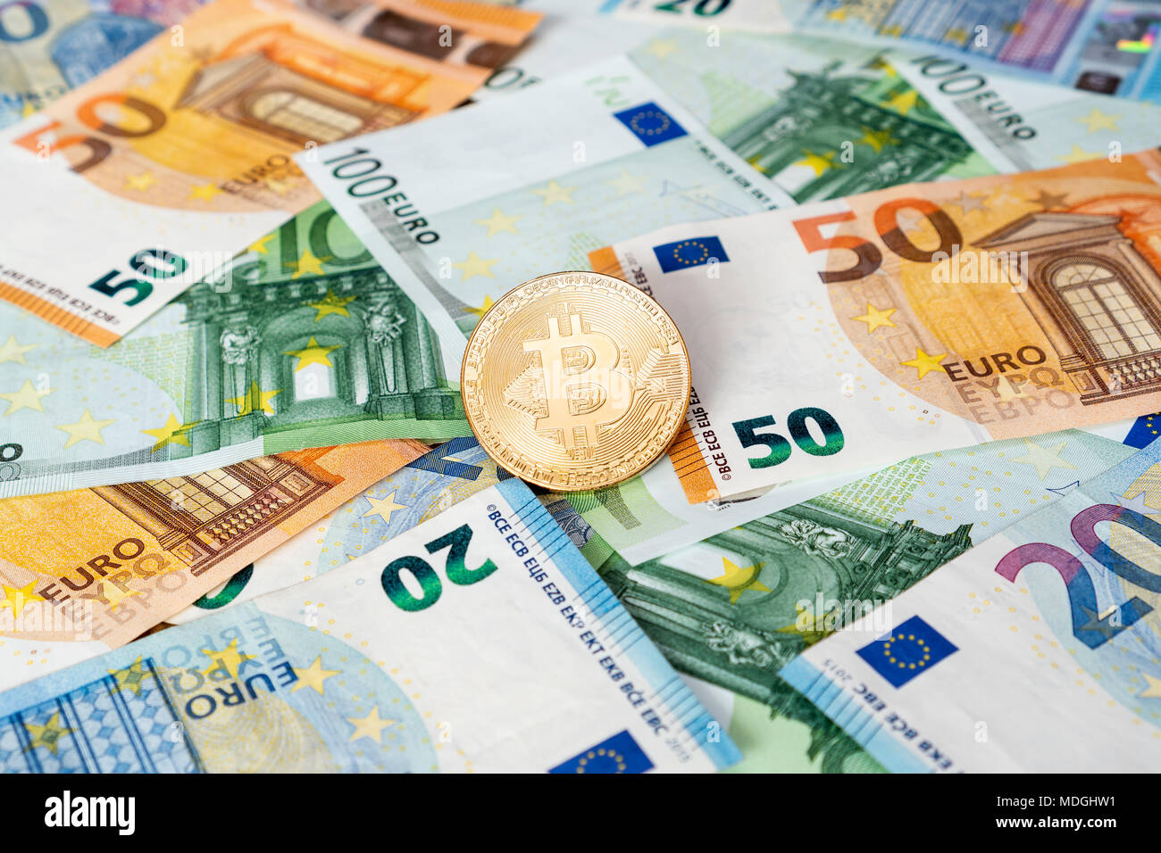 Gold Bitcoin coin on bills of euro banknotes. Worldwide virtual ...
