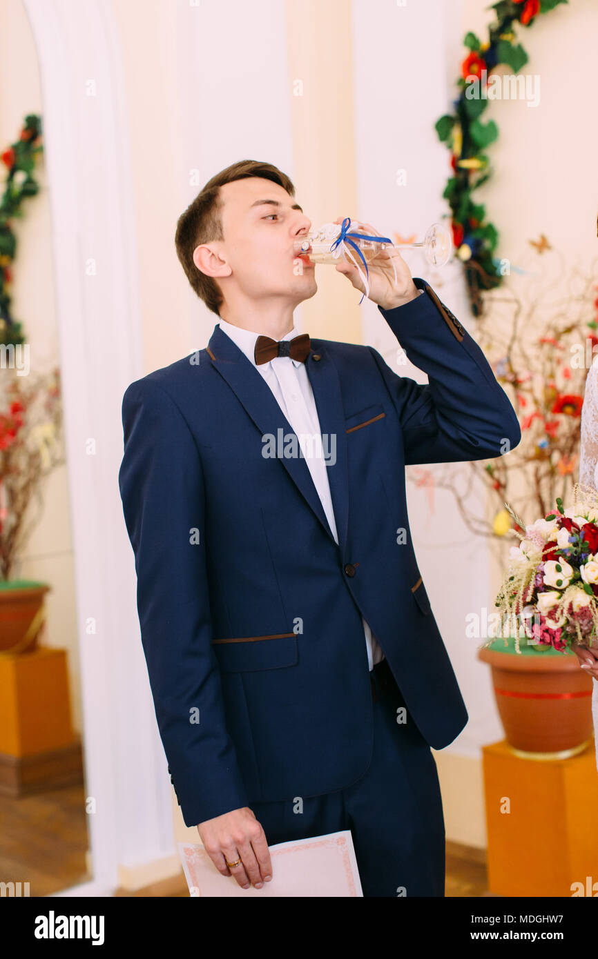 Half-length photo of the groom drinking champagne Stock Photo - Alamy