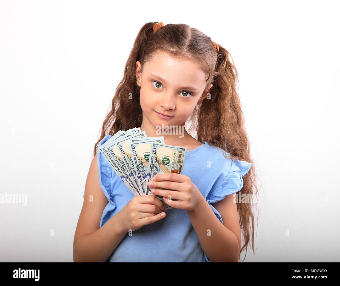 Happy smiling rich kid girl holding money two hands on white background ...
