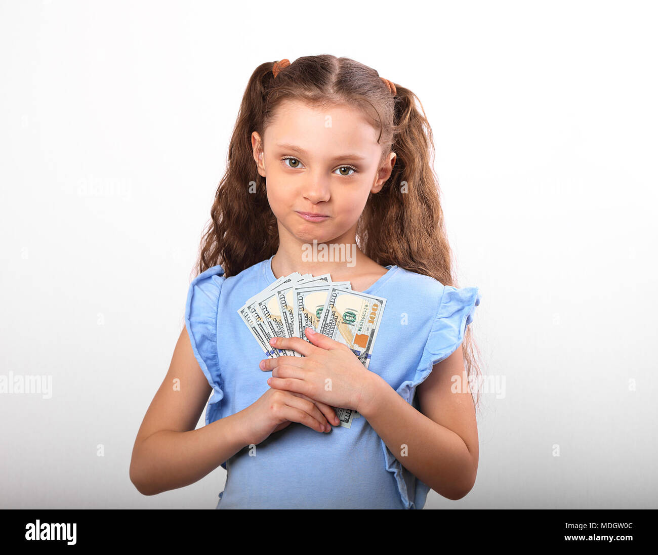 Happy smiling rich kid girl holding money and presseing to the chest on ...