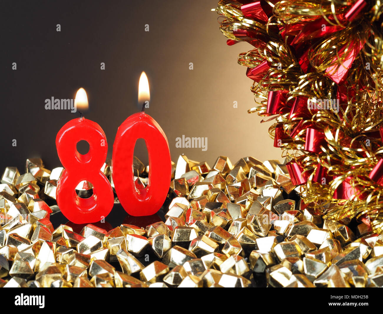 Birthday-anniversary candle showing Nr. 80 Lit red candle good for an ...