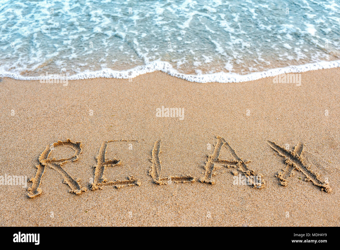 Inscription relax on the sand Stock Photo - Alamy