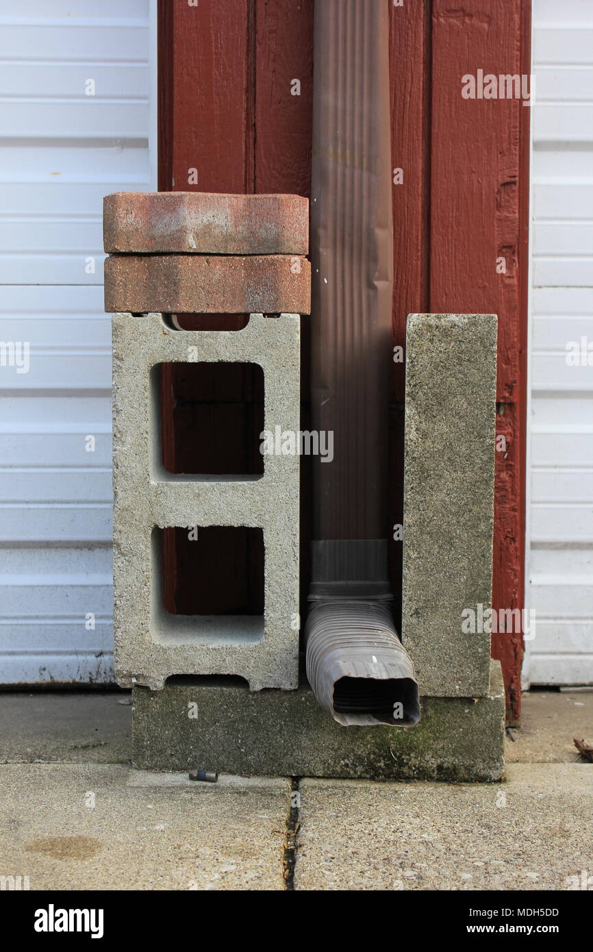 Homemade support for a drainage pipe made out of concrete blocks and ...
