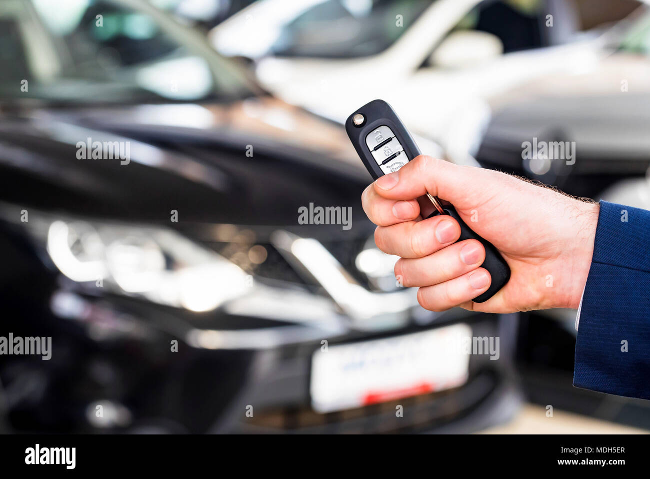 Male hand holds car key in car showroom Stock Photo - Alamy