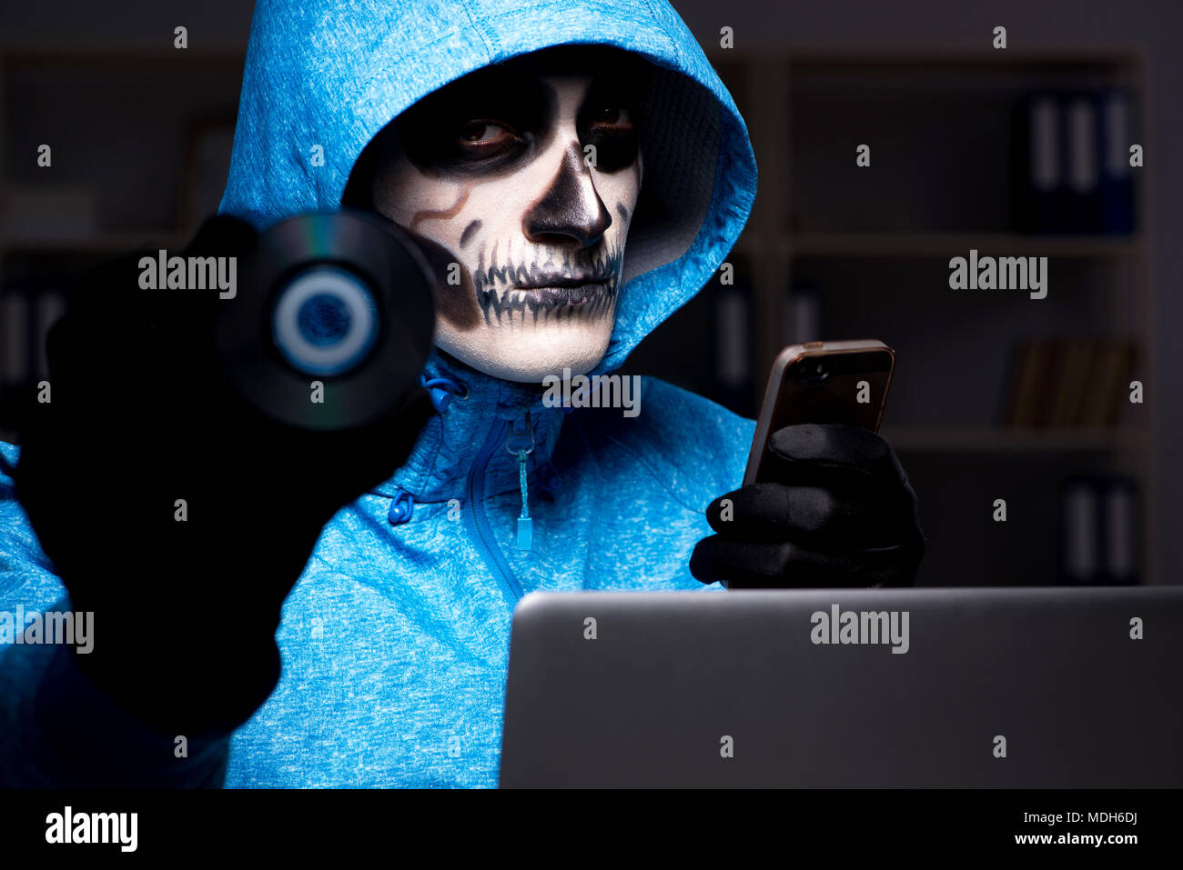 Scary hacker hacking security firewall late in office Stock Photo - Alamy