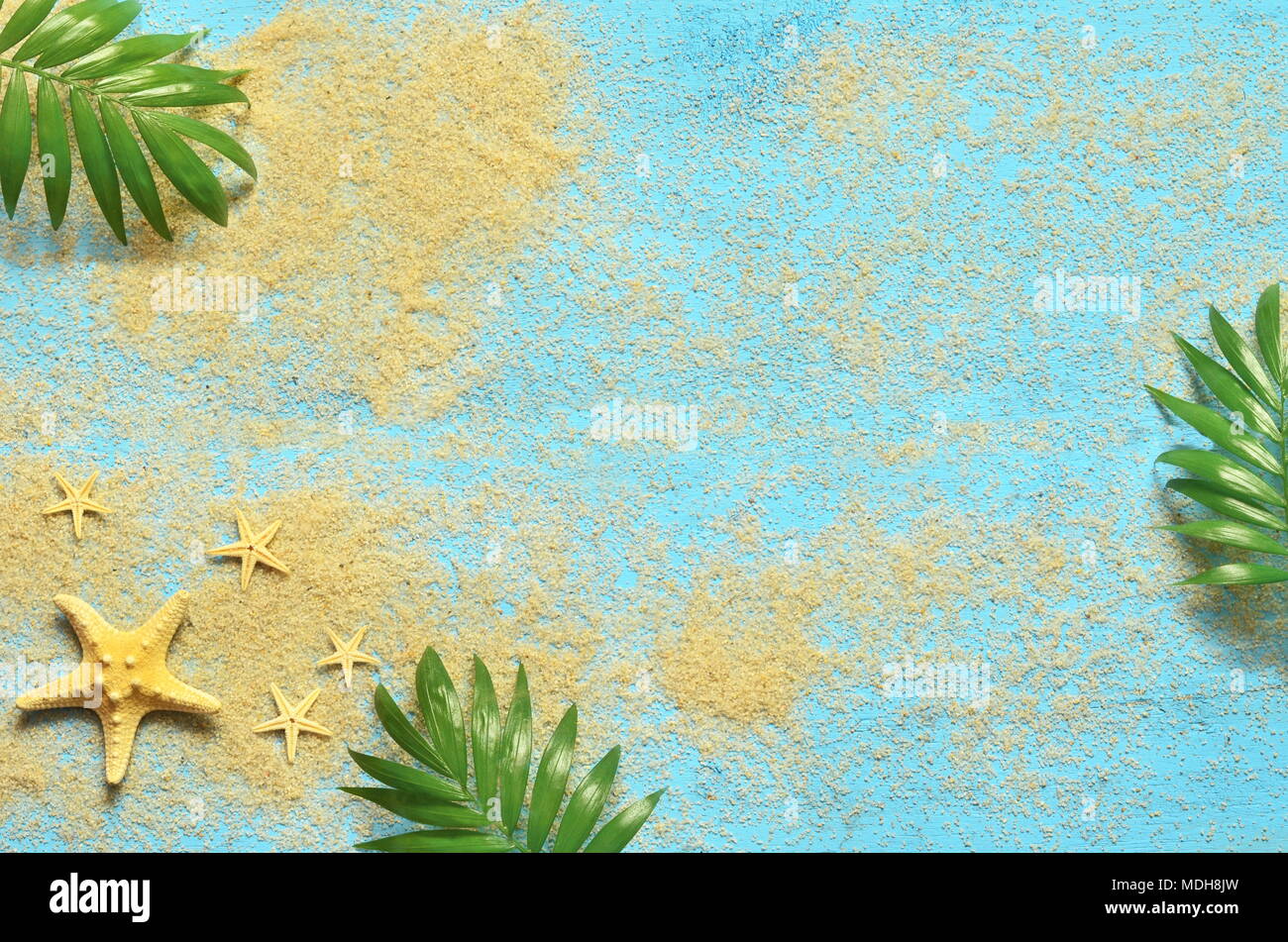 Summer sea background. Starfish and palm branch on a wooden blue ...