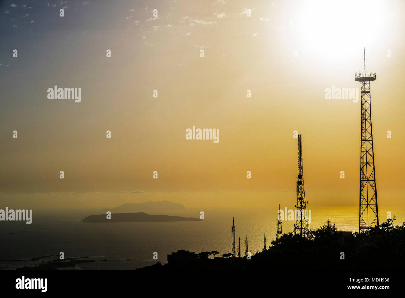 Silhouettes of telecommunications towers at sunset in the coast of ...