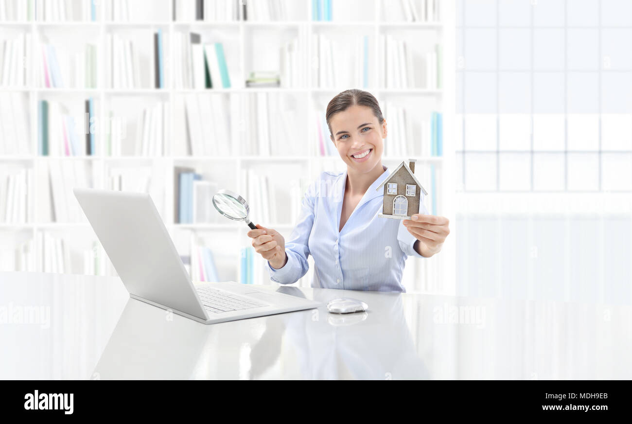 real estate office, smiling woman agent working on computer with ...
