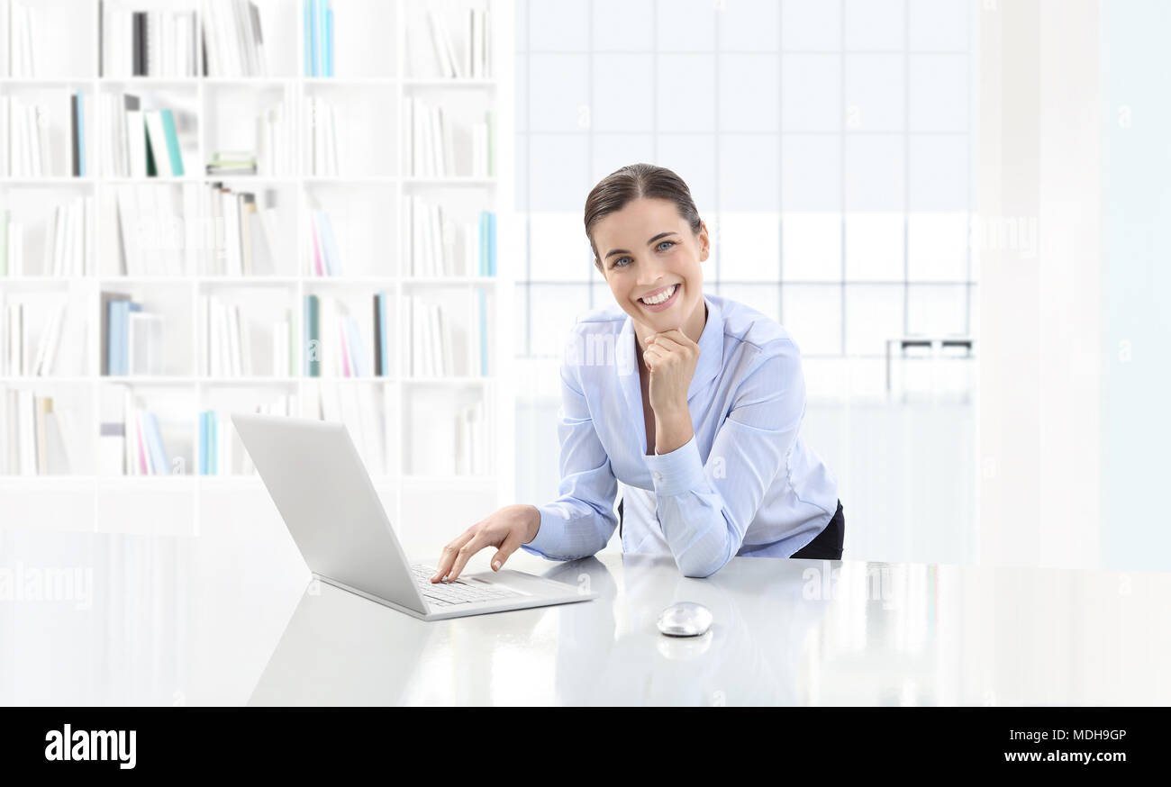 Business smiling woman or a clerk working at her office desk with ...