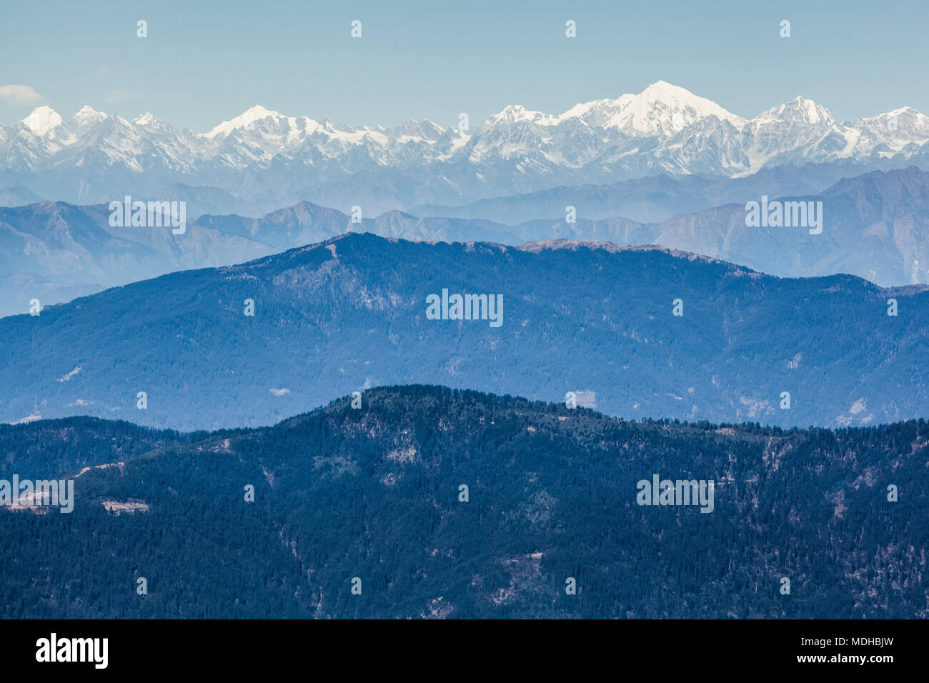 Layers of mountains in the Himalayas with snow-capped peaks in the ...