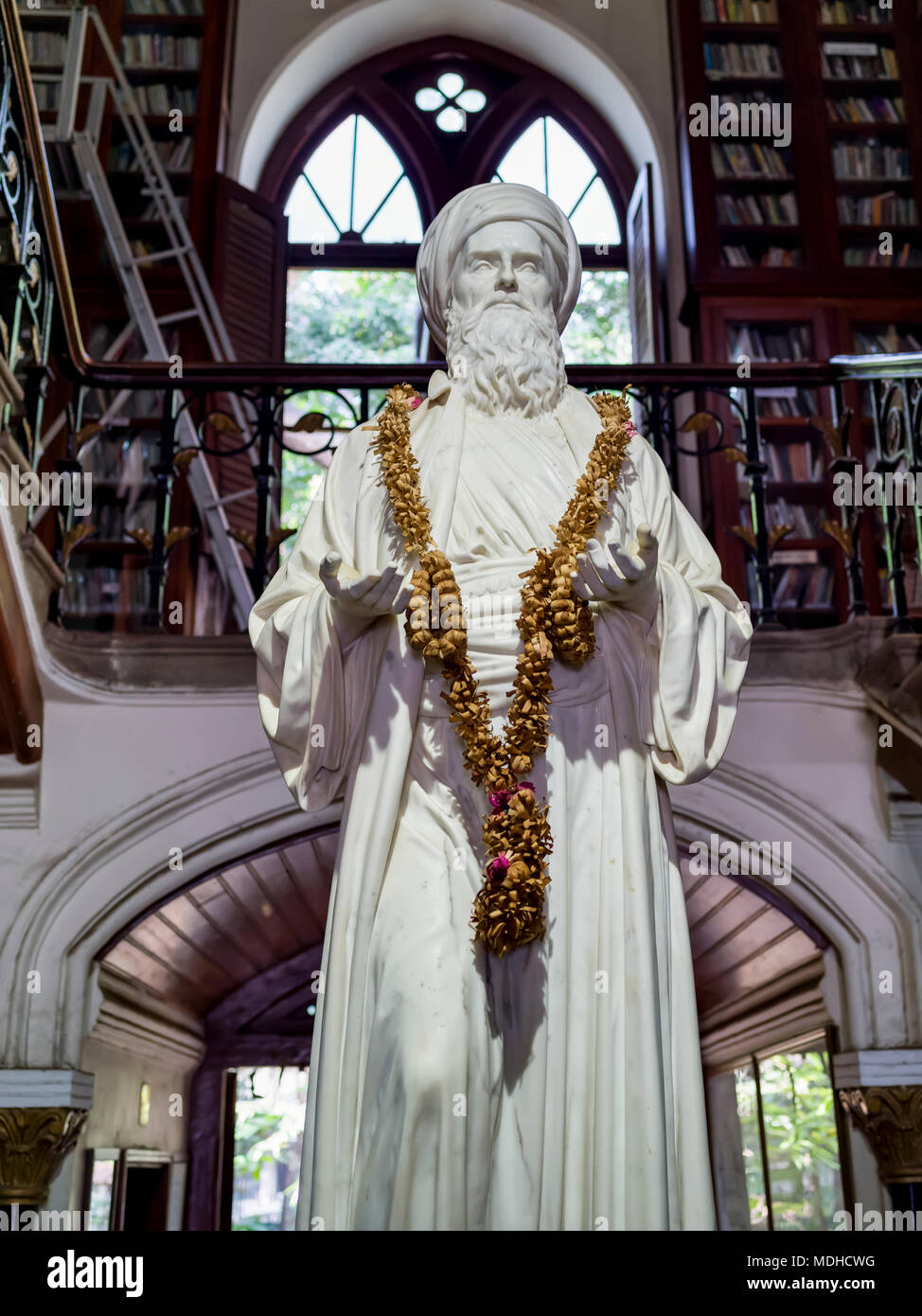 White statue of a male figure with garland draped around it's neck and ...