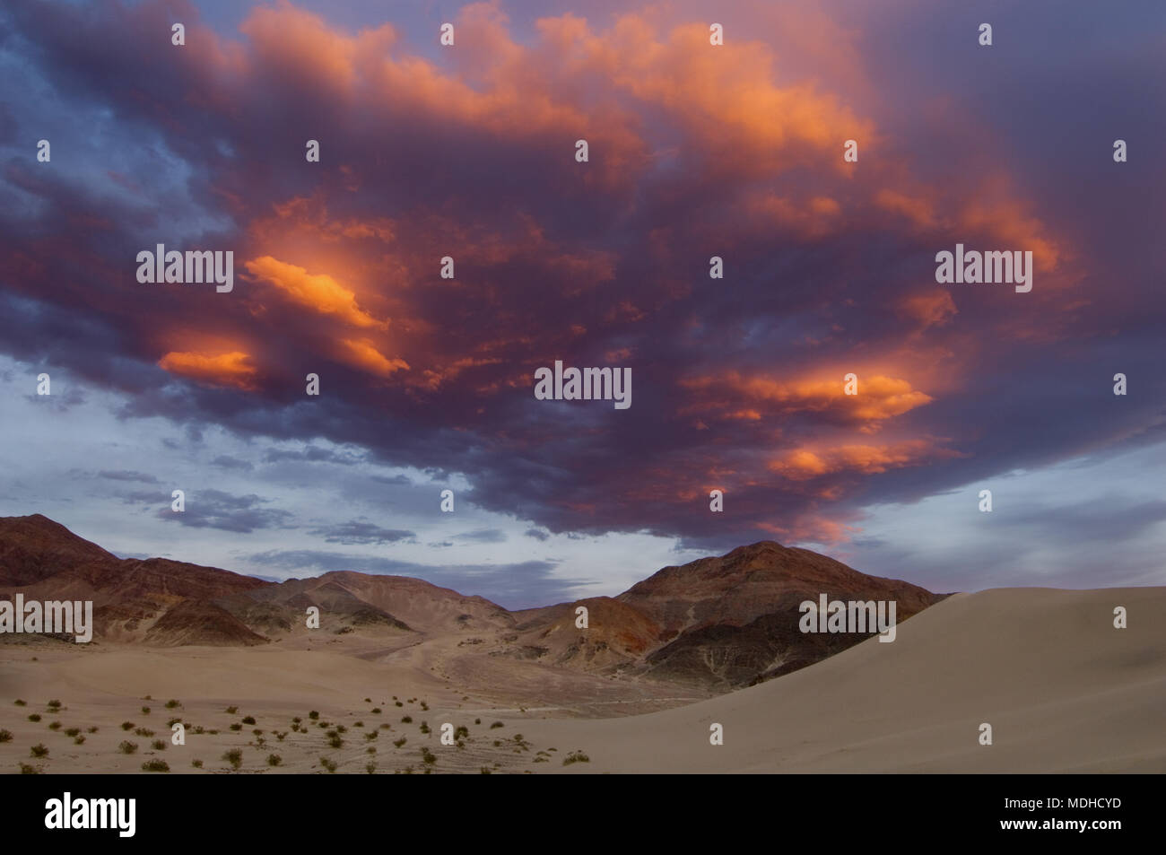 Sand dunes and a fiery sunset create a dramatic landscape Stock Photo ...