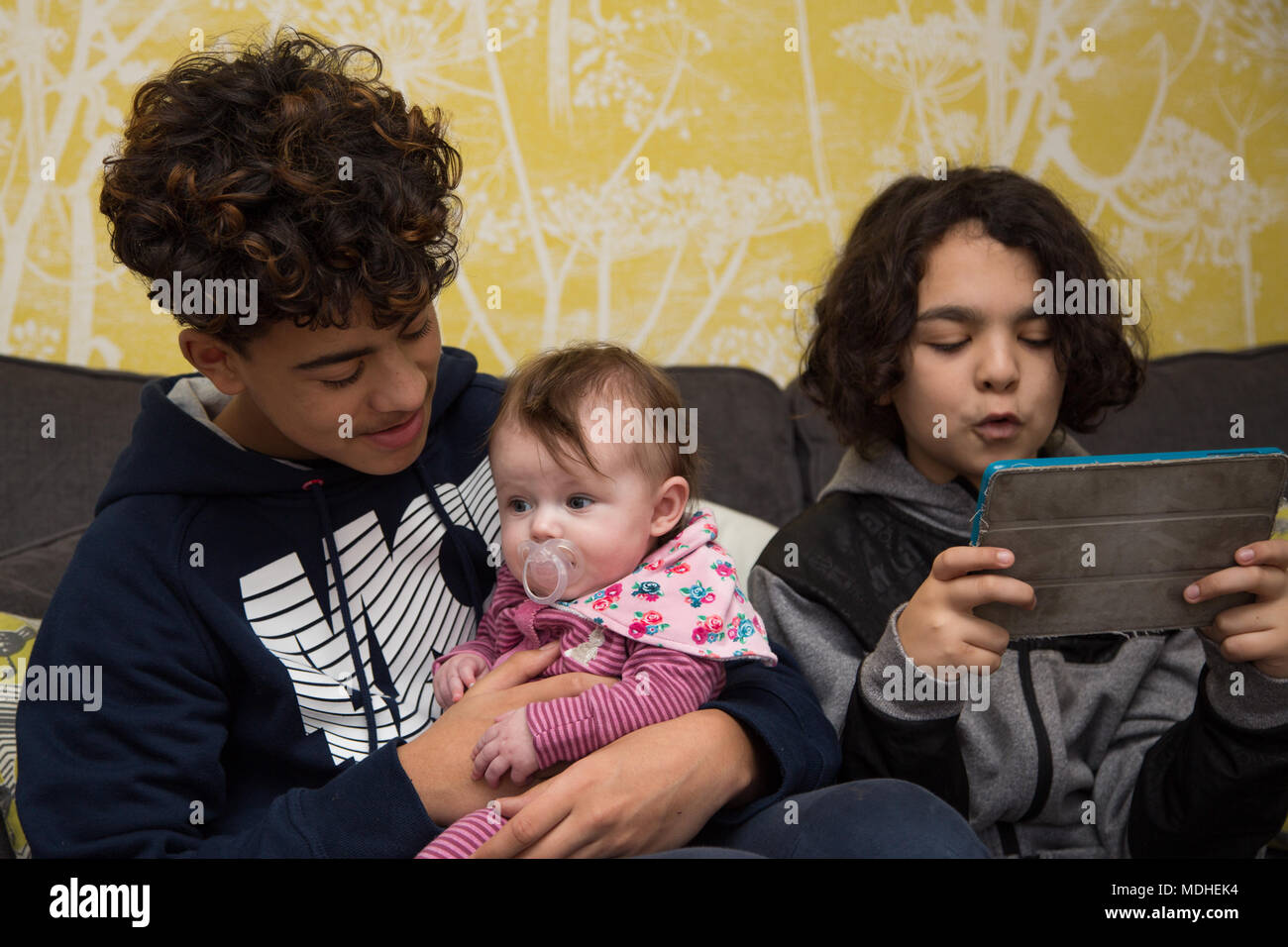 Young children babysitting Stock Photo - Alamy