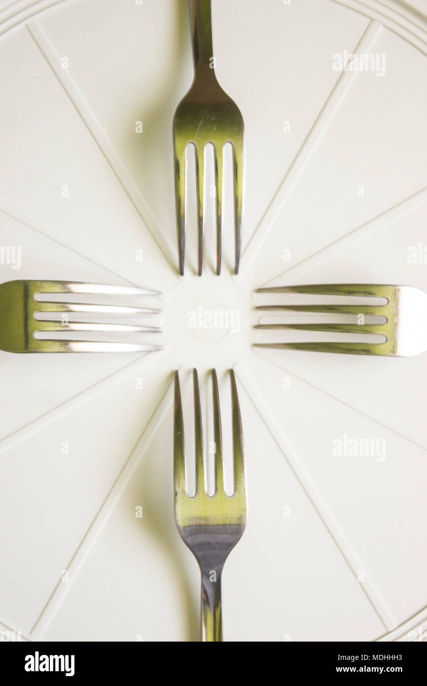 four fork pointing to the center on white background Stock Photo - Alamy