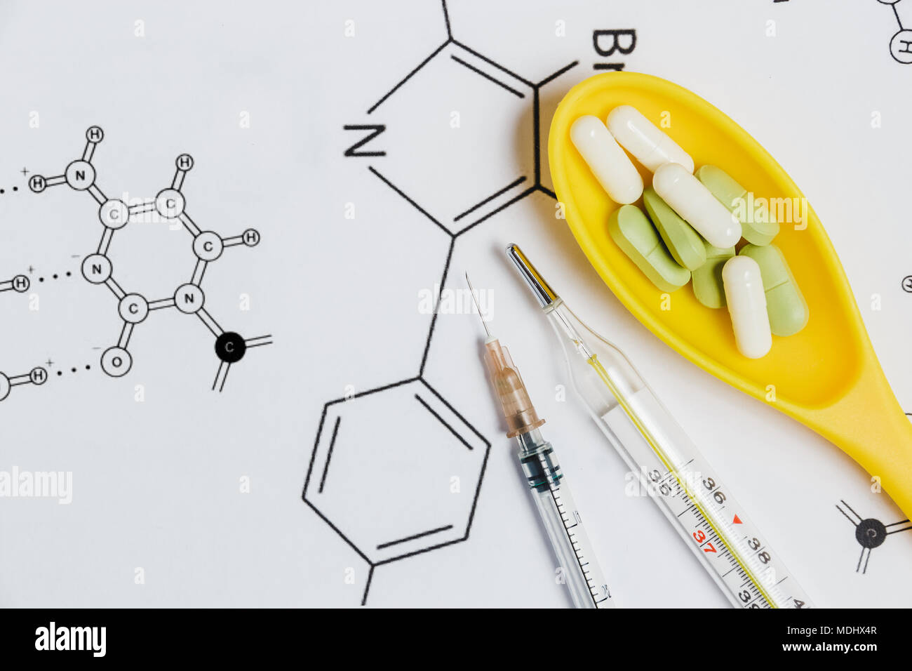 Assortment of Pills and Capsules in Yellow Spoon, Syringe, Thermometer ...