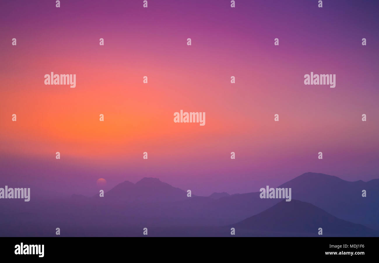 A pink and purple sky with silhouetted mountains; Namibia Stock Photo ...