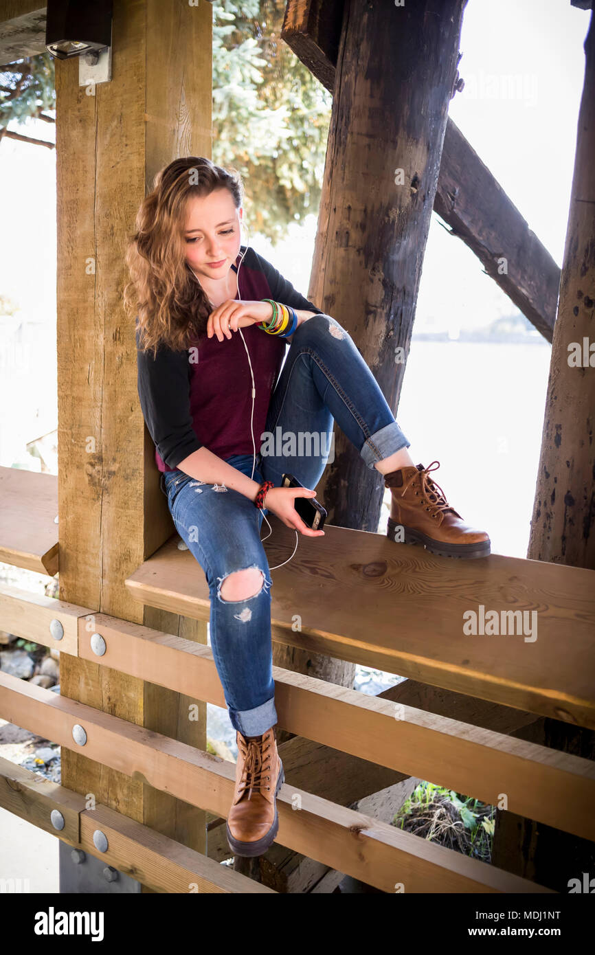 Woman sitting on the edge of a railing hi-res stock photography and ...