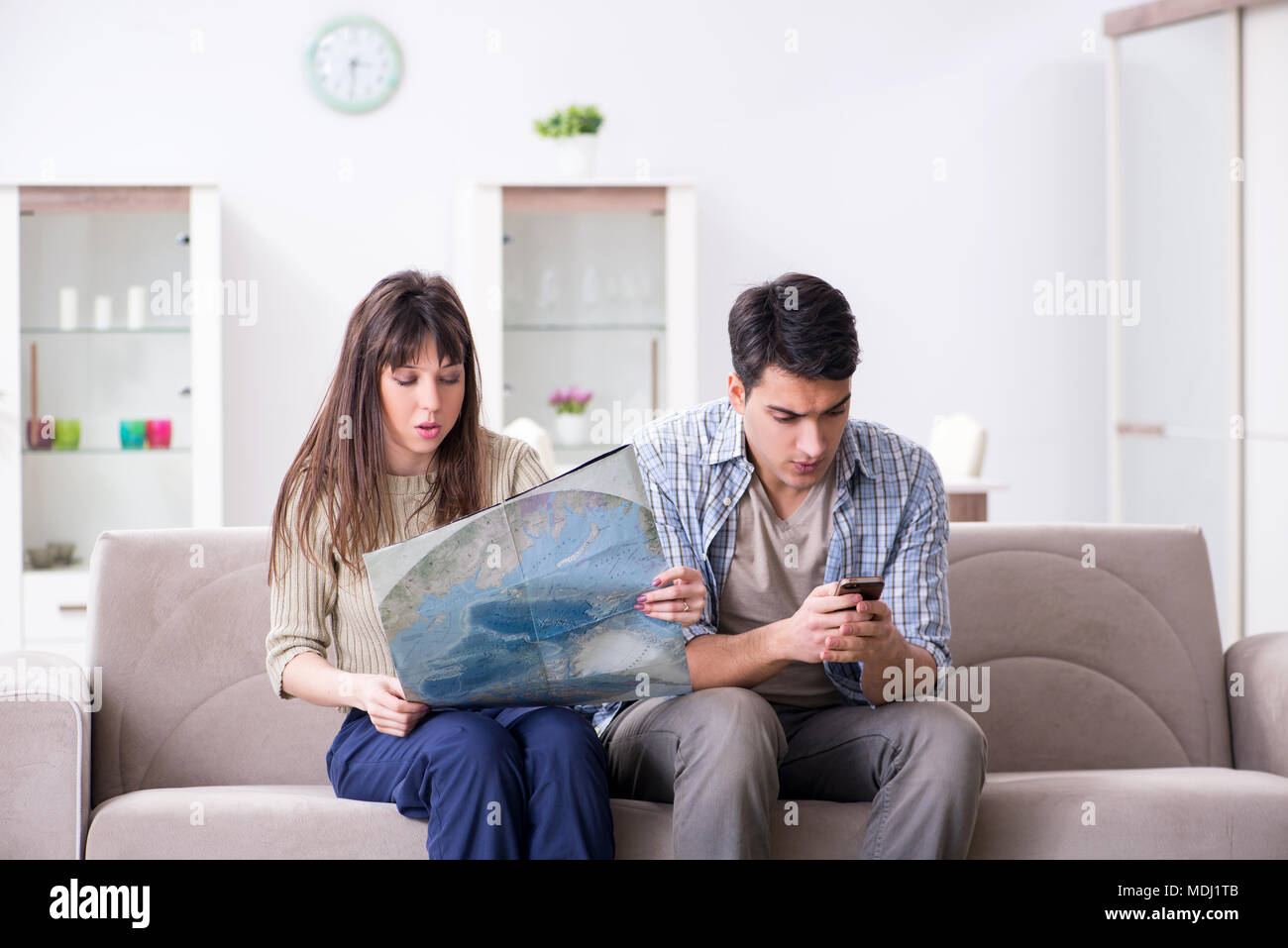 Young family discussing travel plans with map Stock Photo - Alamy