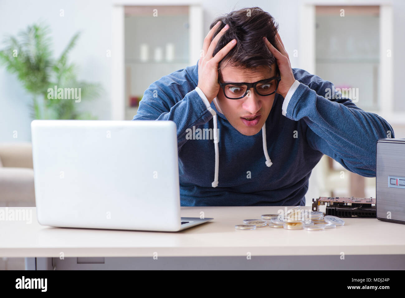 Young man mining bitcoins at home Stock Photo - Alamy