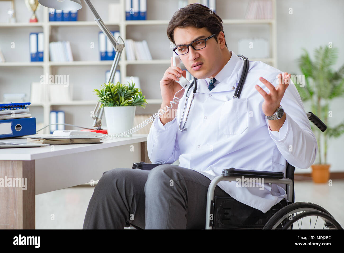 Disabled doctor on wheelchair working in hospital Stock Photo - Alamy