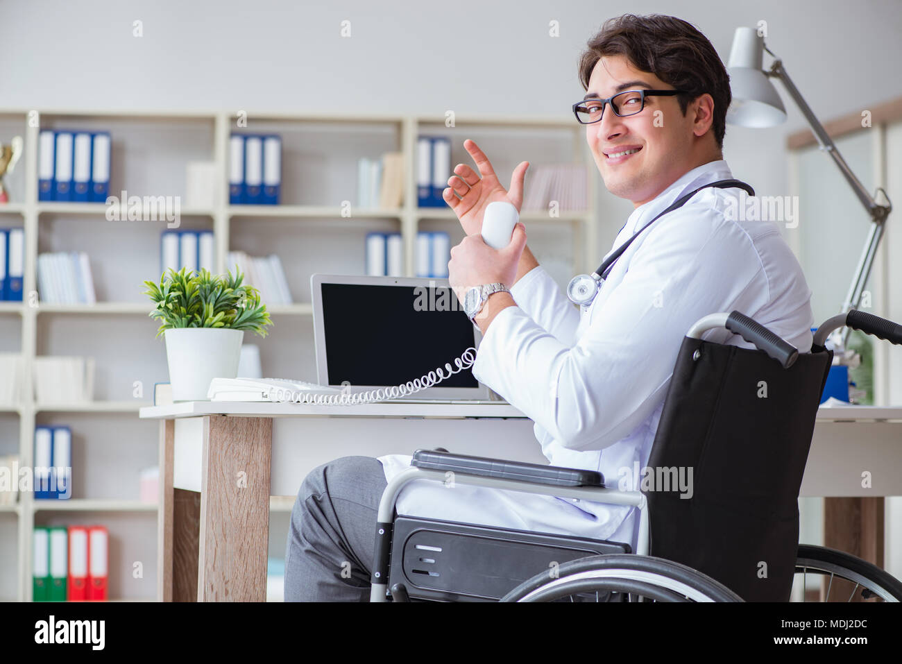 Disabled doctor on wheelchair working in hospital Stock Photo - Alamy