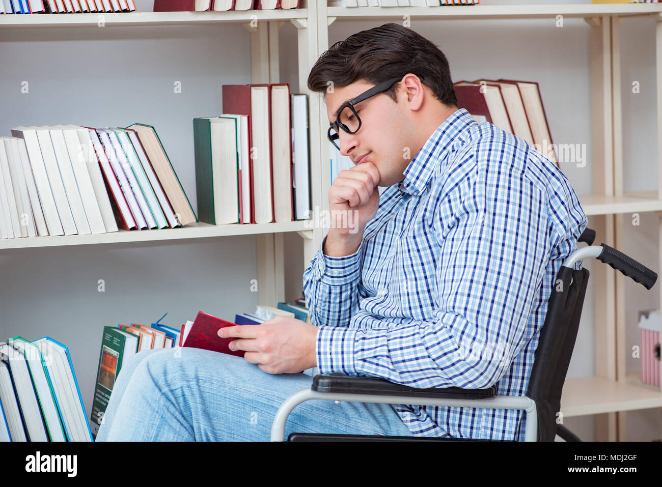 Disabled student studying in the library Stock Photo - Alamy