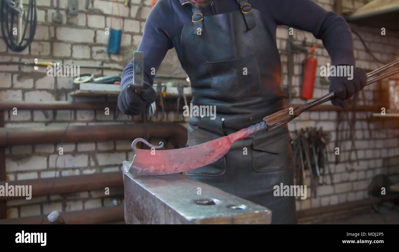 The blacksmith manually forging in the smithy Stock Photo - Alamy