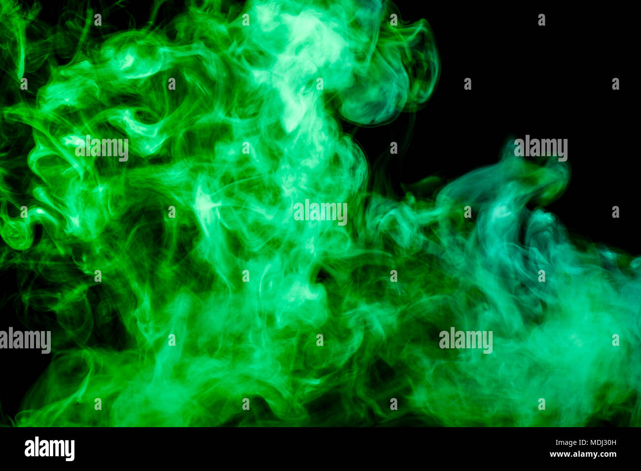 Thick colorful green smoke on a black isolated background. Background ...