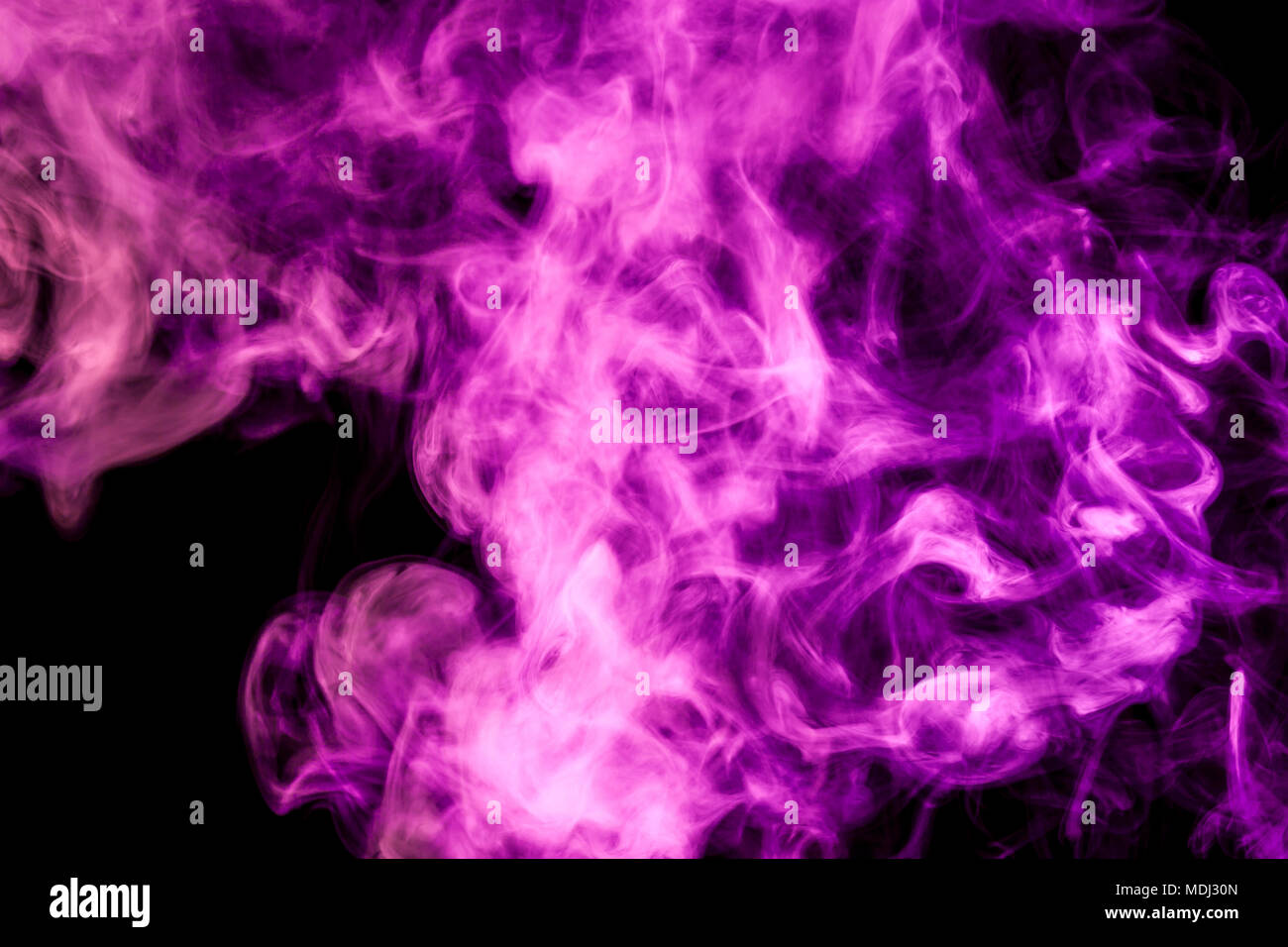Thick colorful pink and red smoke on a black isolated background ...