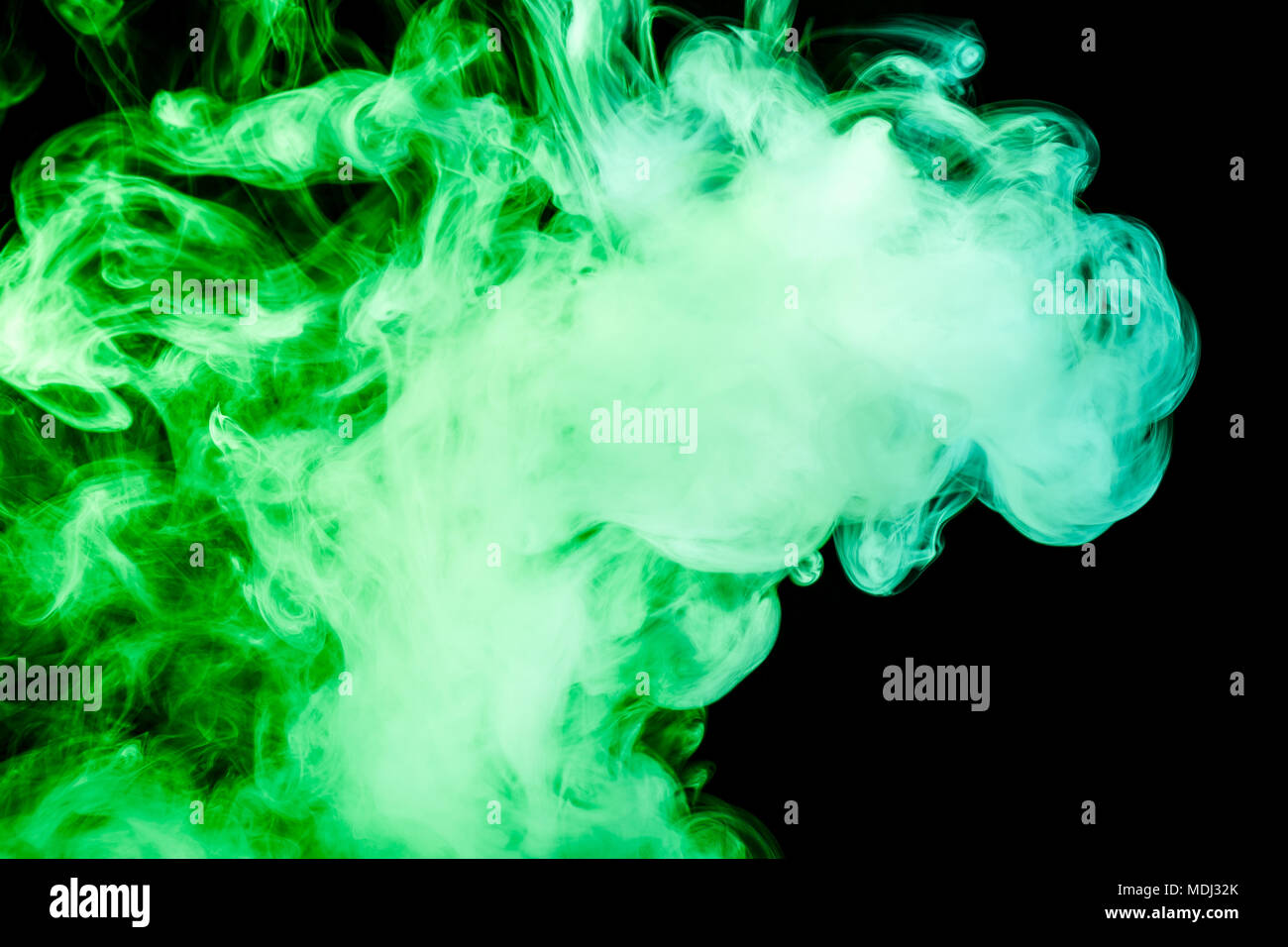 Thick colorful green smoke on a black isolated background. Background ...